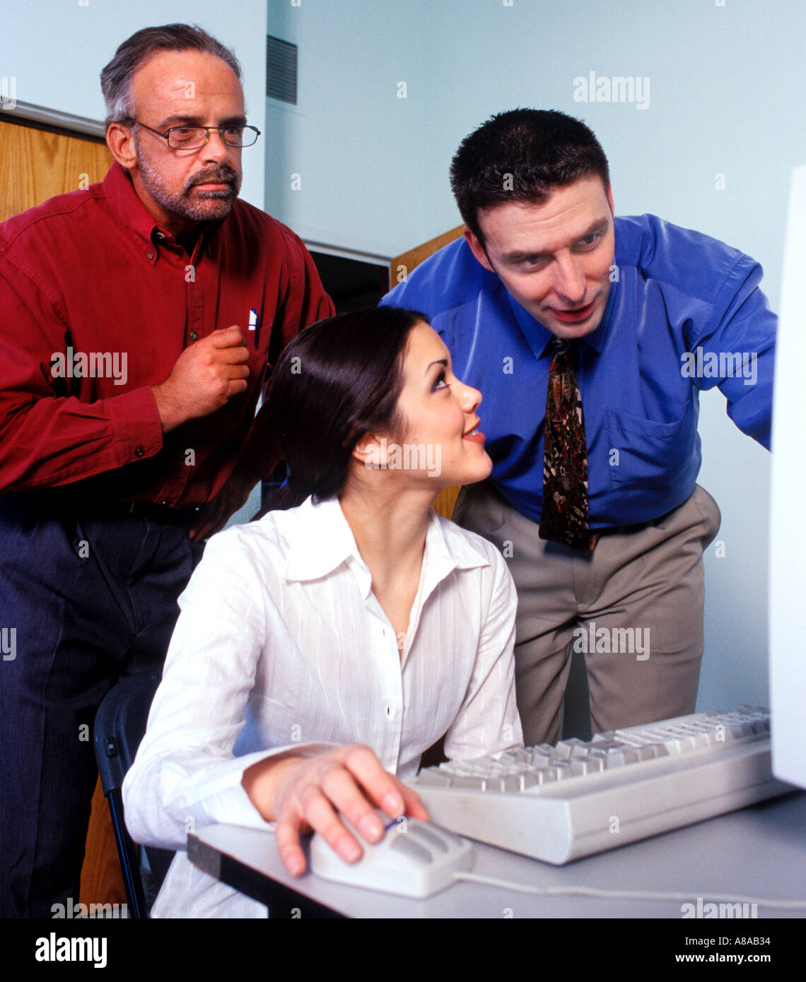 Three Business People at a Computer Terminal Stock Photo - Alamy