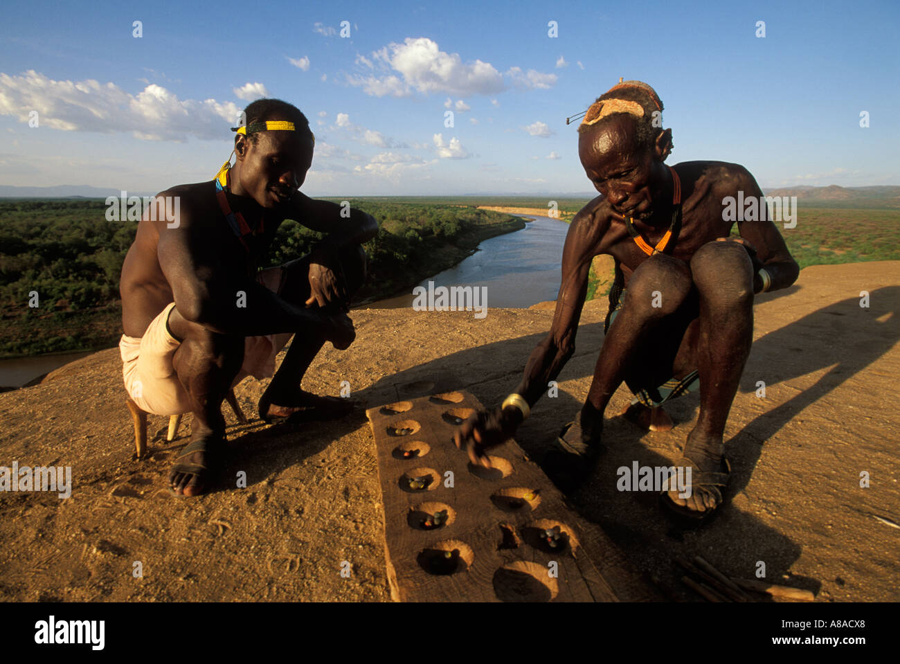 Karo men playing bao game at the Omo river , Kolcho , South Omo Valley ...
