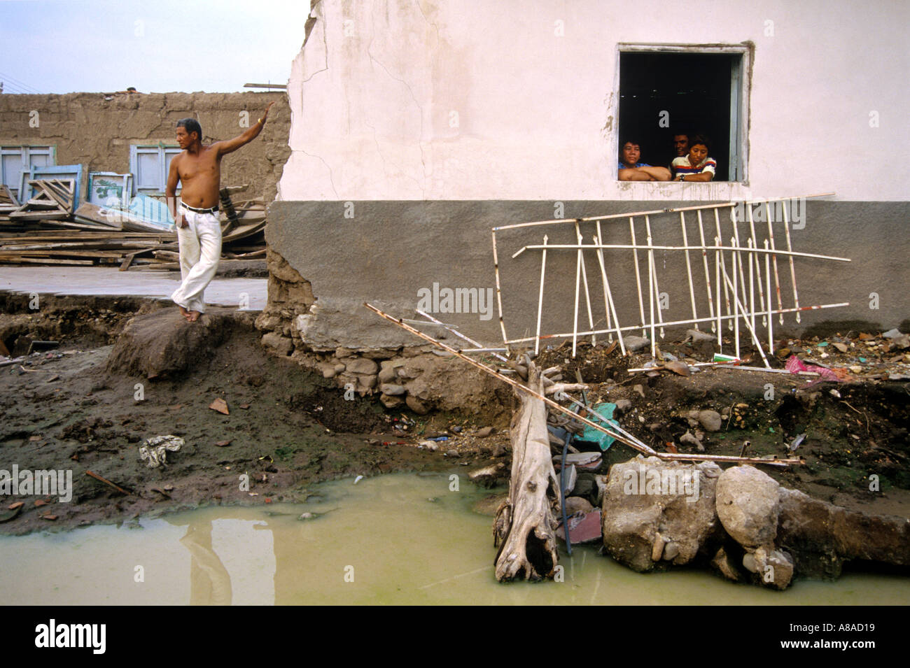 A family poses by their home destroyed by the passage of Hurricane ...