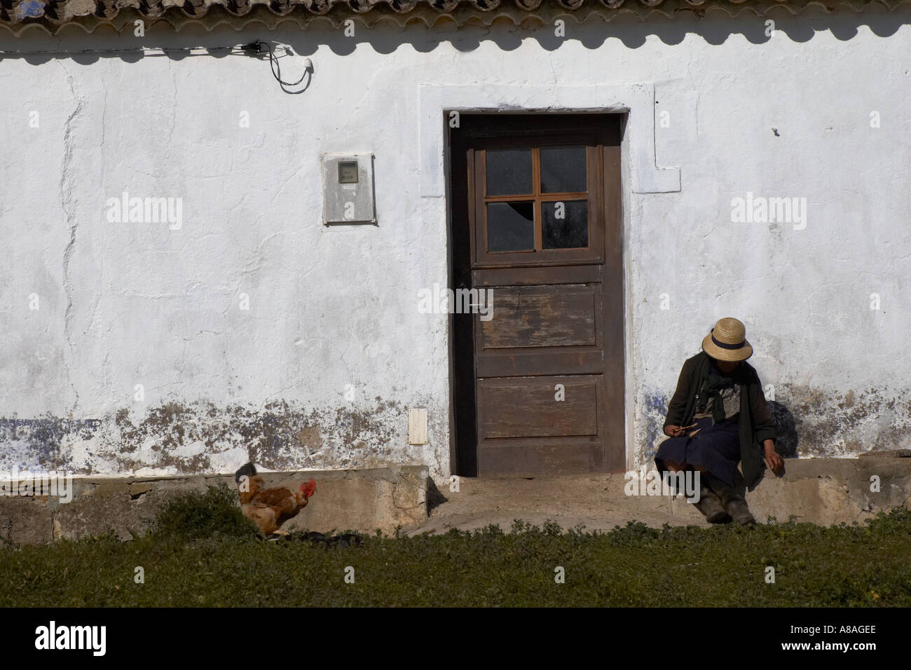 Elderly Portuguese lady sitting outside her typical Algarvian farmhouse ...