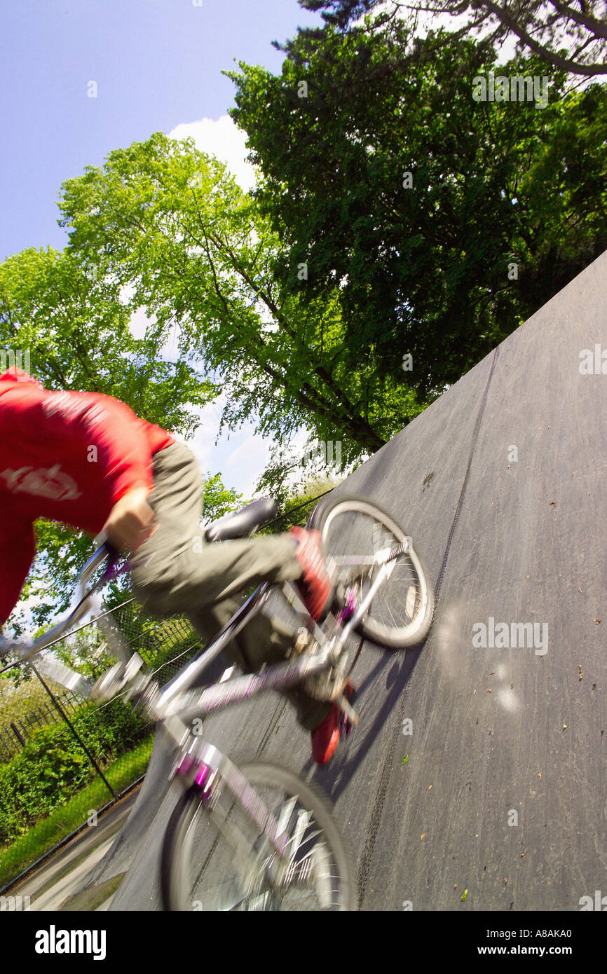 Blurred person on a BMX bike cycling down a ramp out of shot in a UK ...