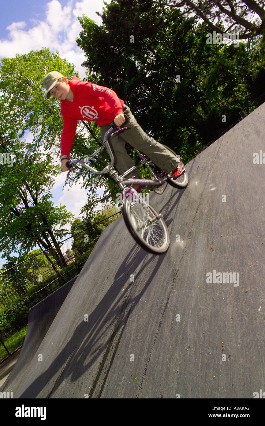 Blurred person on a BMX bike cycling down a ramp out of shot in a UK ...