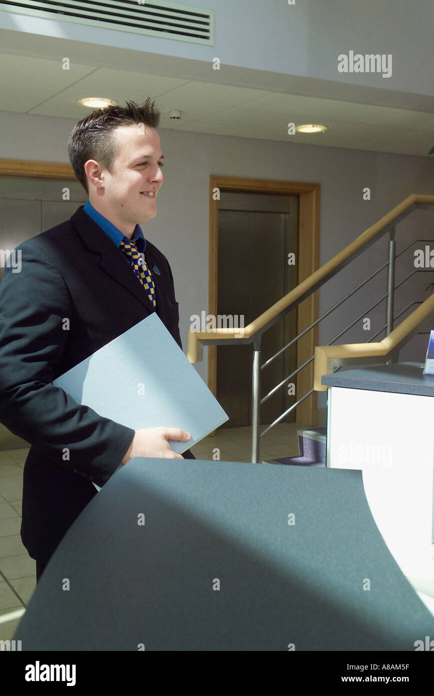 One Businessman with folder of notes at reception desk of IT Centre ...