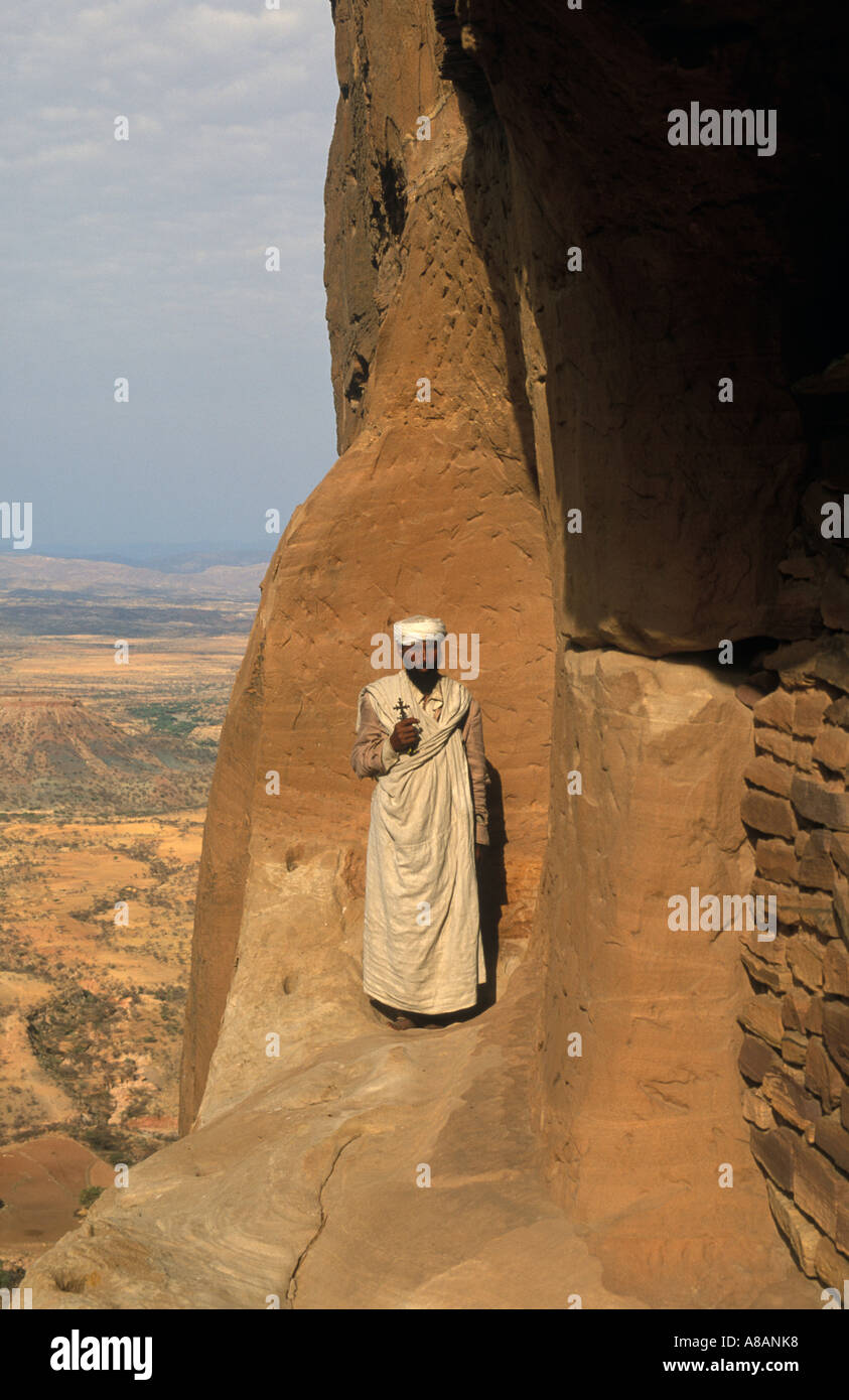 Priest on cliff entrance of Abuna Yemata Guh rock-hewn church ...