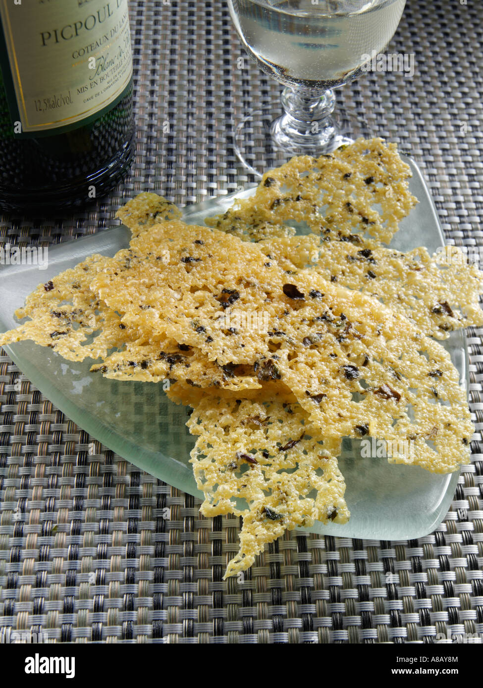 Seaweed cheese wafers and a glass of white wine editorial food Stock ...