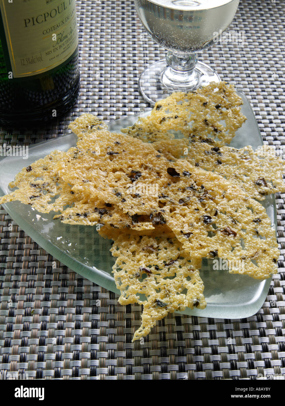 Seaweed cheese wafers and a glass of white wine editorial food Stock ...