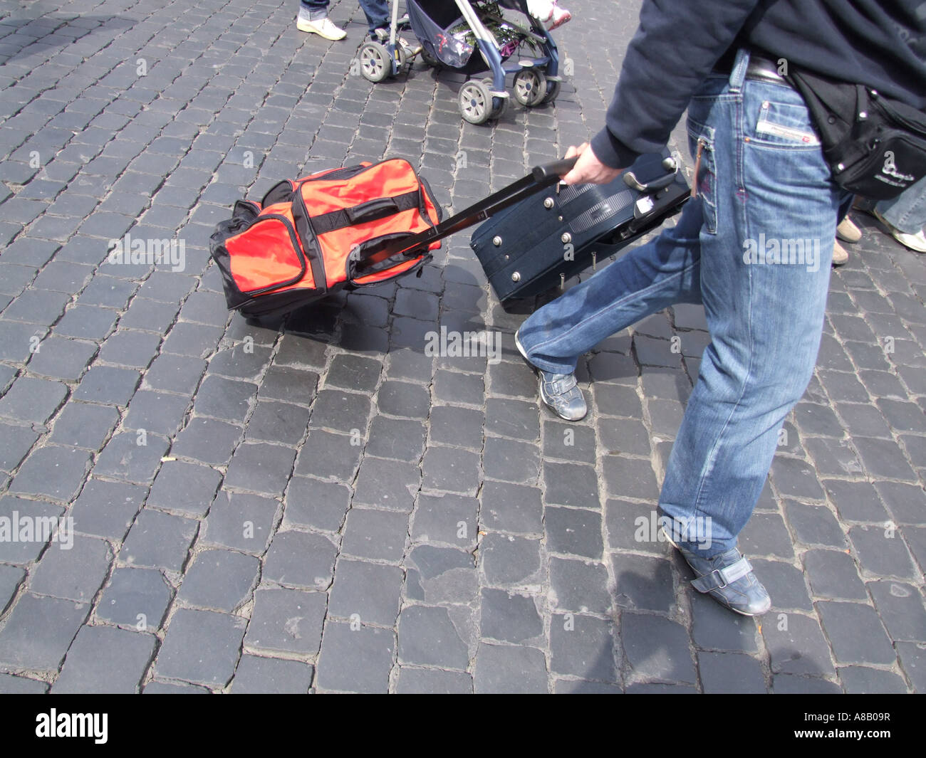 man pulling trolley case in town Stock Photo - Alamy