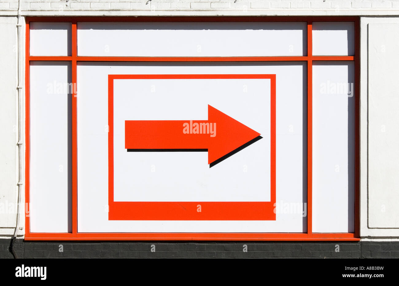 red arrow direction sign outside retail outlet Stock Photo - Alamy