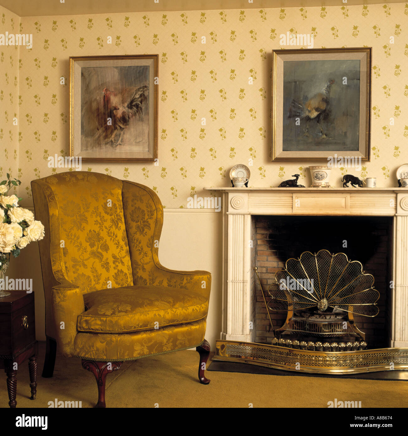 Gold brocade armchair beside fireplace with fan-shaped fireguard in ...