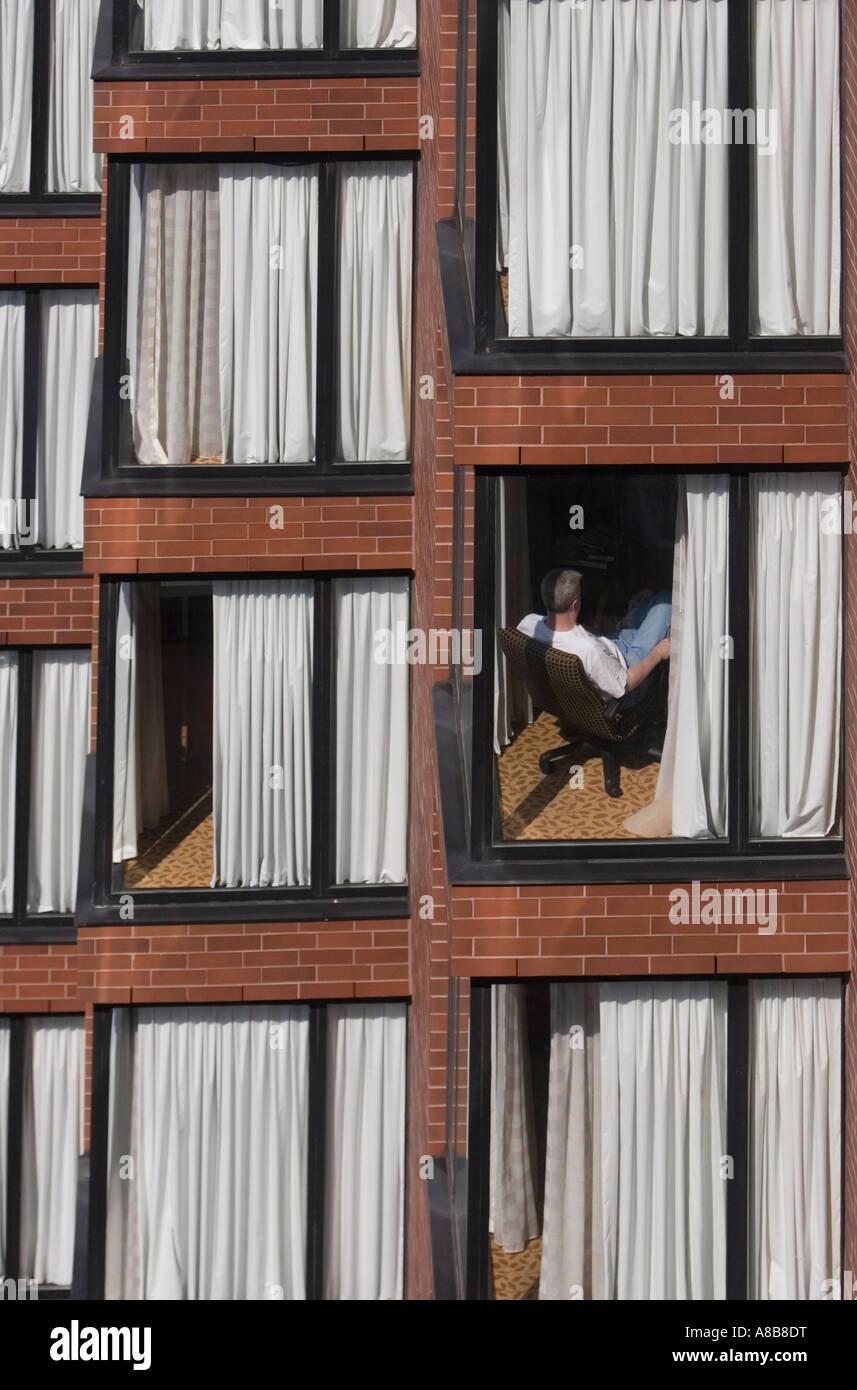 Man sitting by a building window Stock Photo - Alamy