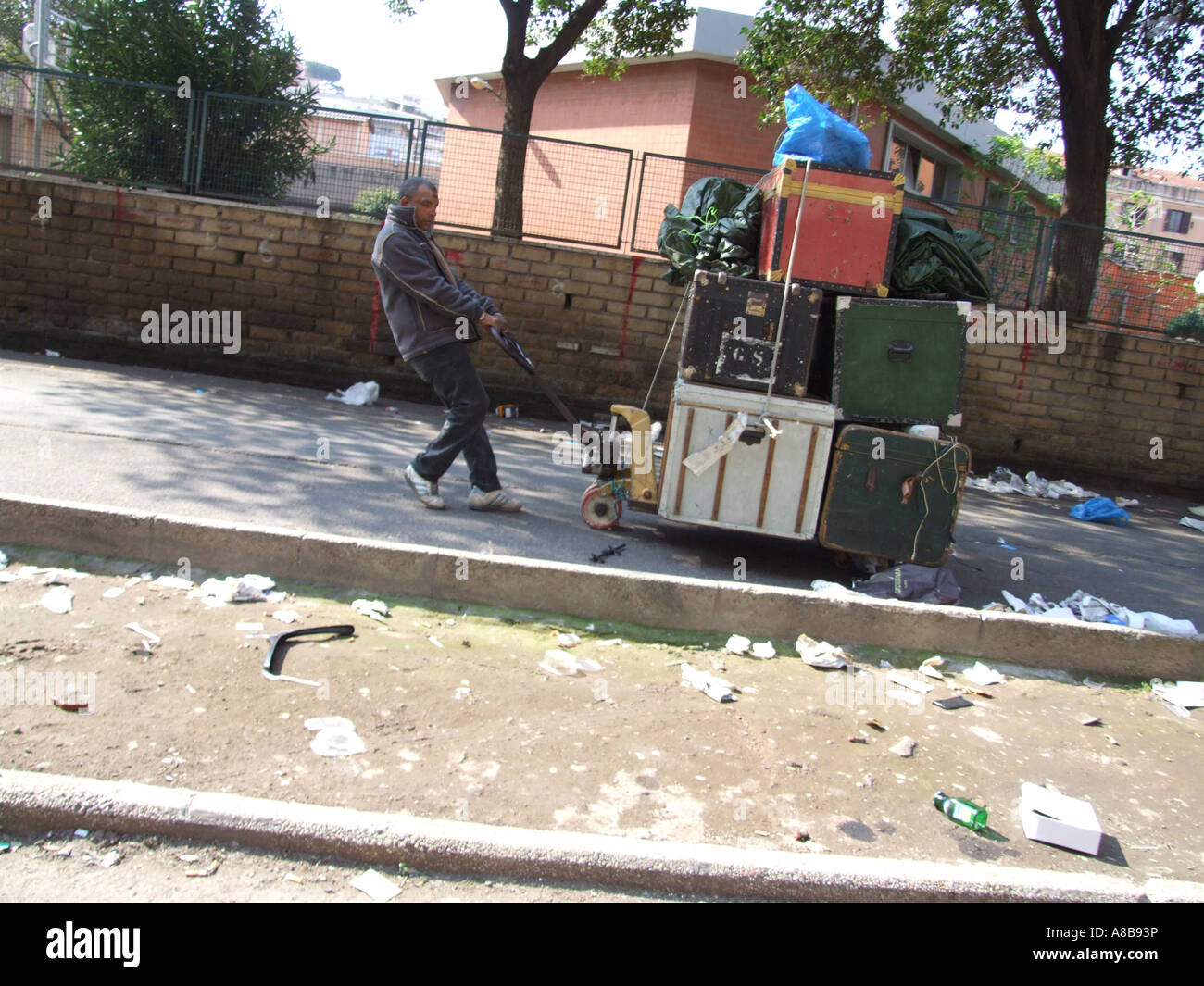 man pulling trolley full of boxes at porta portese market in rome italy ...