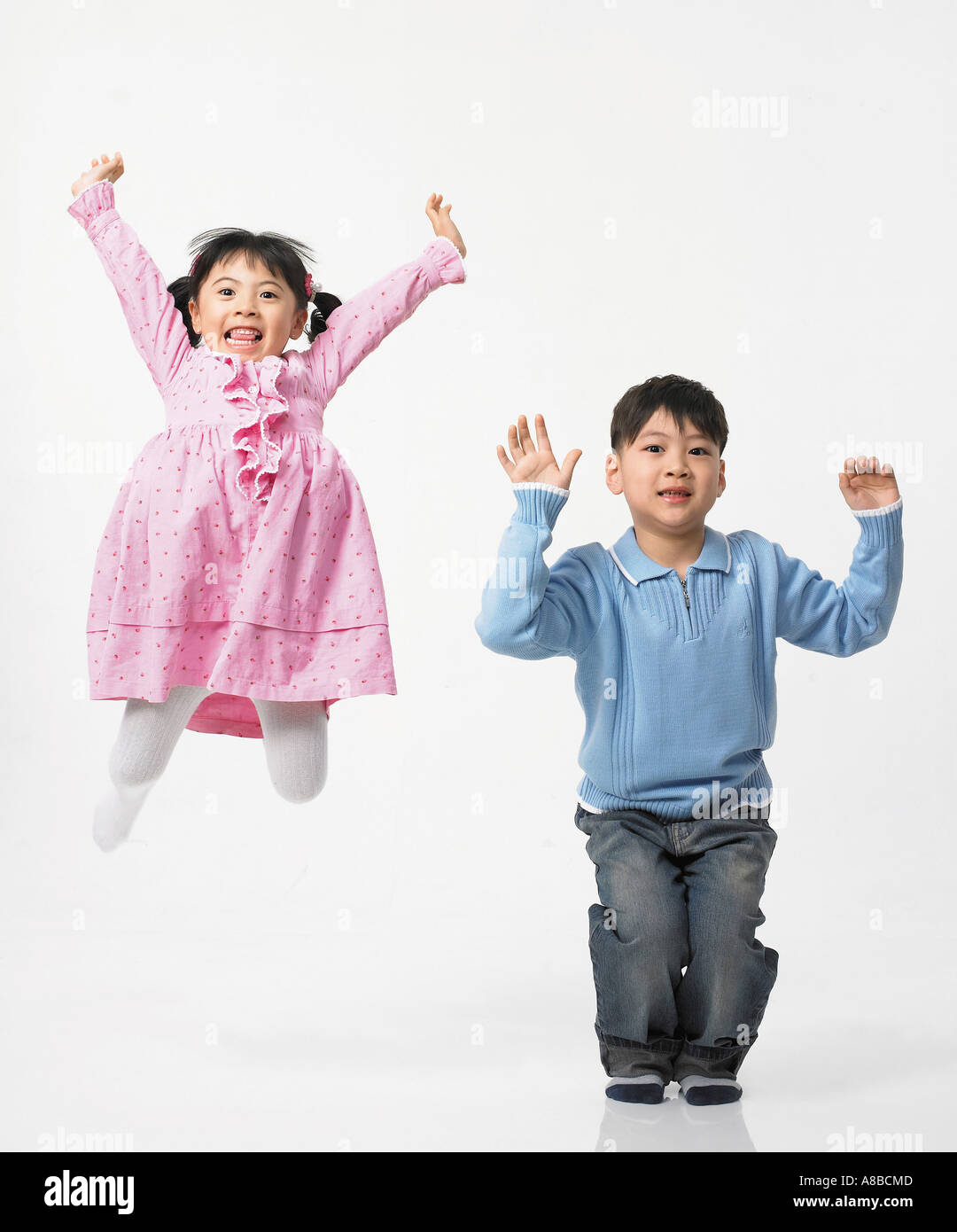 a girl is jumping high and the boy is ready for jump Stock Photo - Alamy