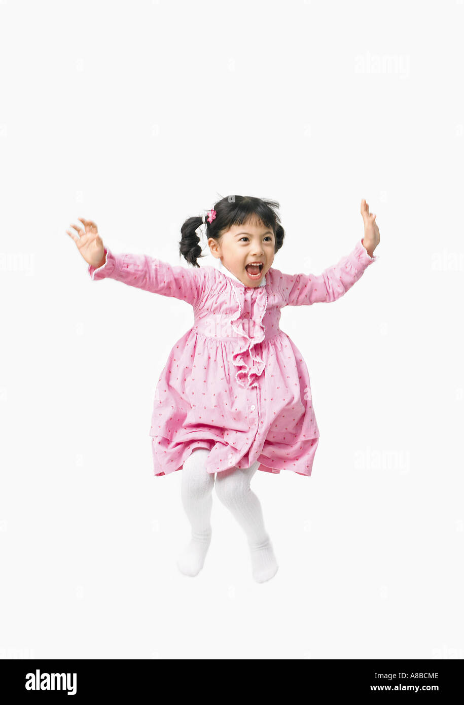 a girl is jumping up with a smile Stock Photo - Alamy