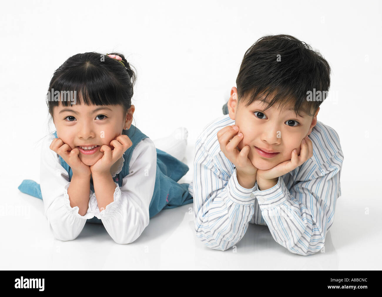 a boy and a girl rested their chin in hands Stock Photo - Alamy