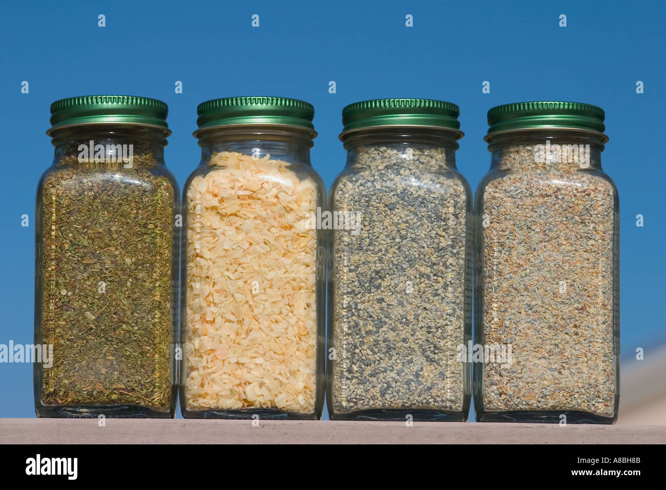 Four spice bottles in a row Stock Photo - Alamy