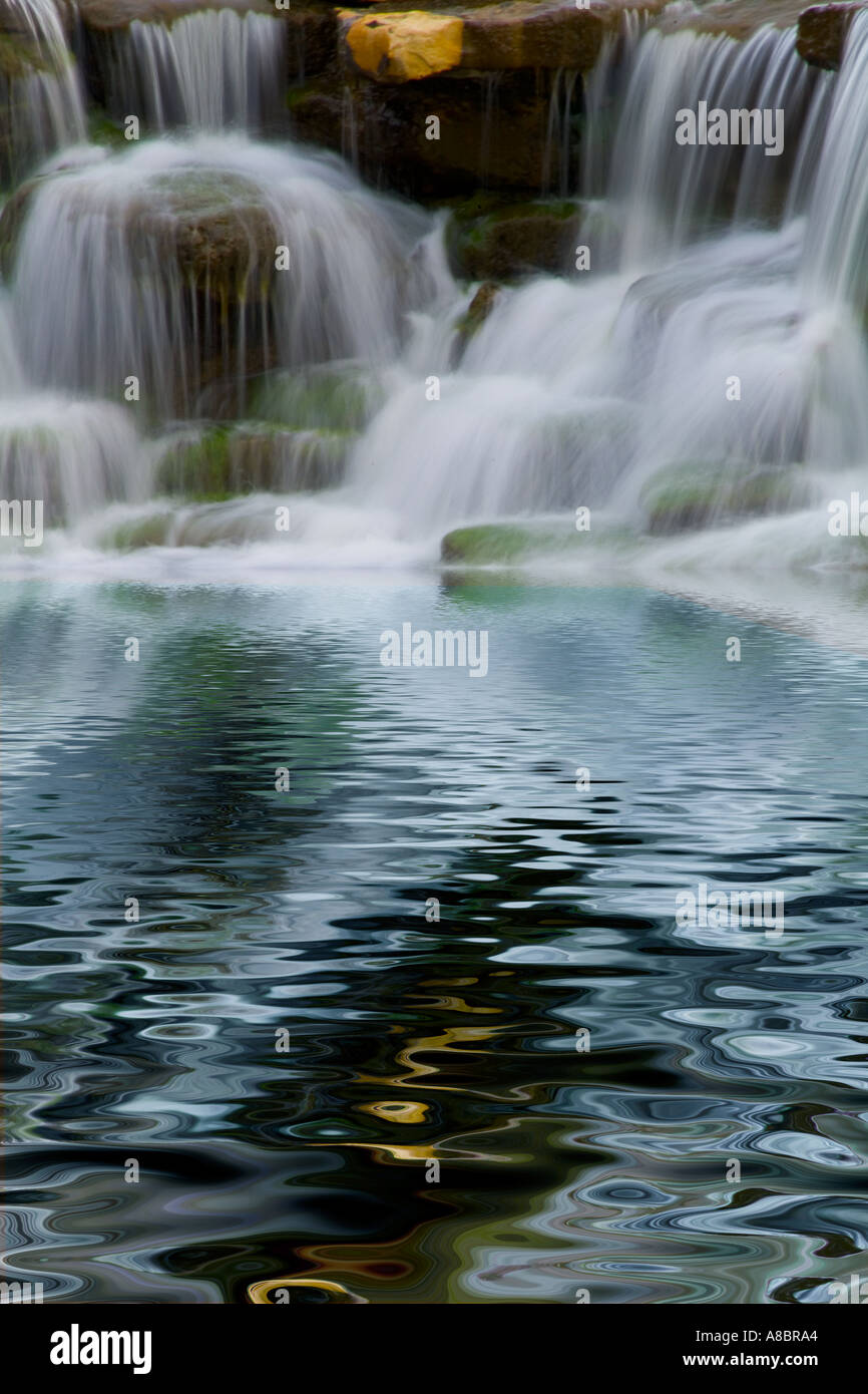 Waterfall motion shot cascading over rocks into blue pool Stock Photo ...