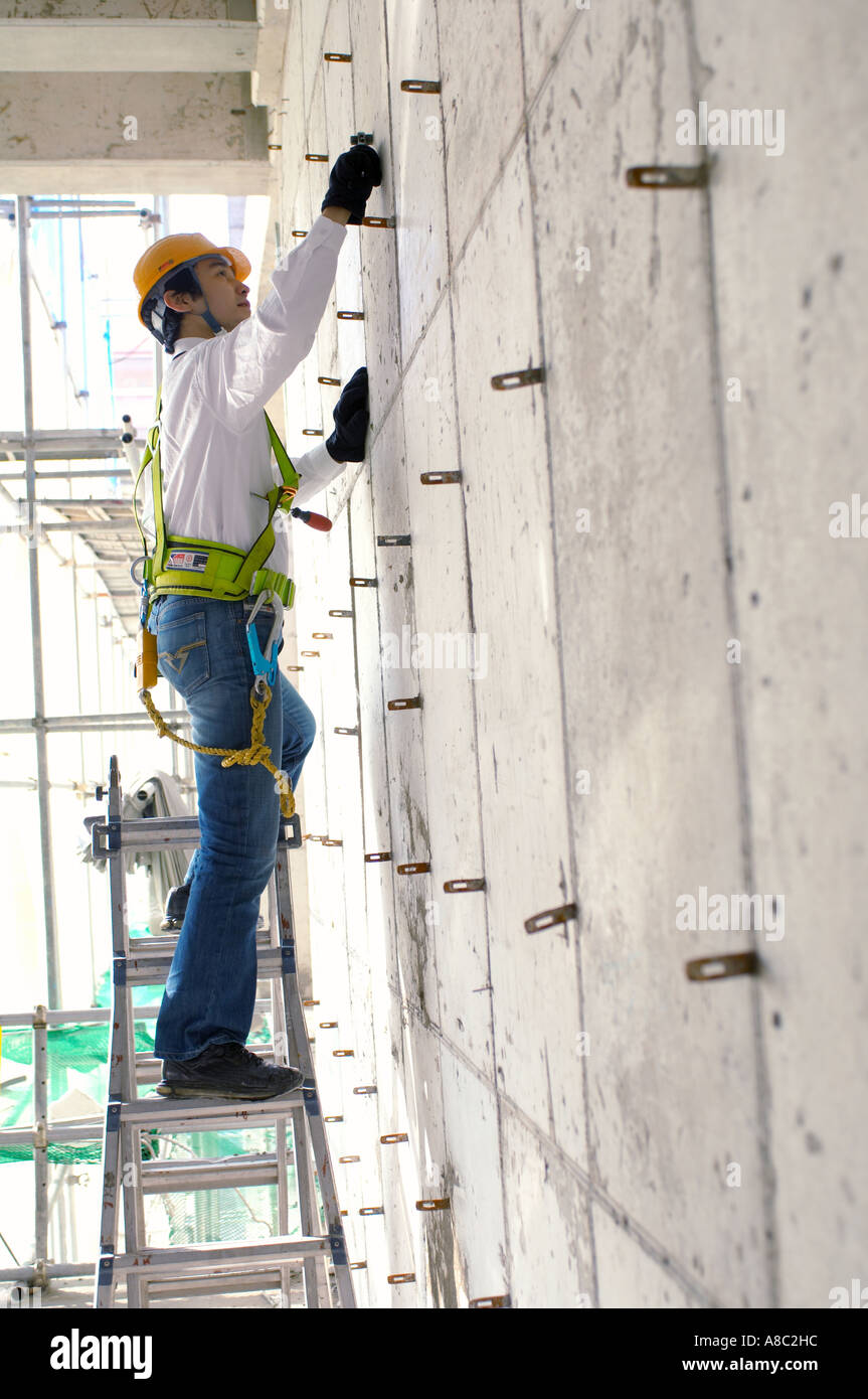 at a construction place a worker working on a ladder Stock Photo - Alamy