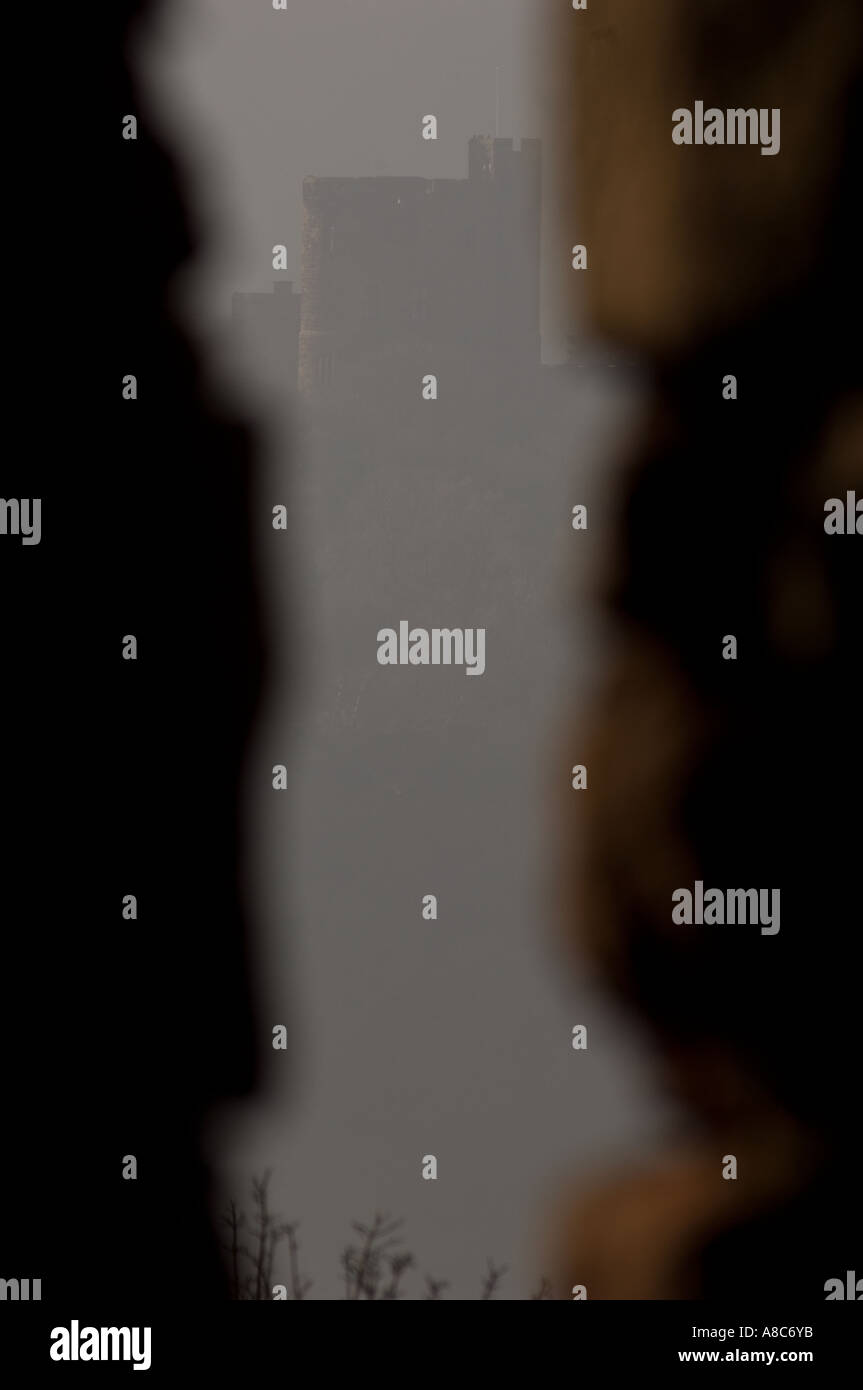 A misty view of a castle through the arrow slit of another castle ...