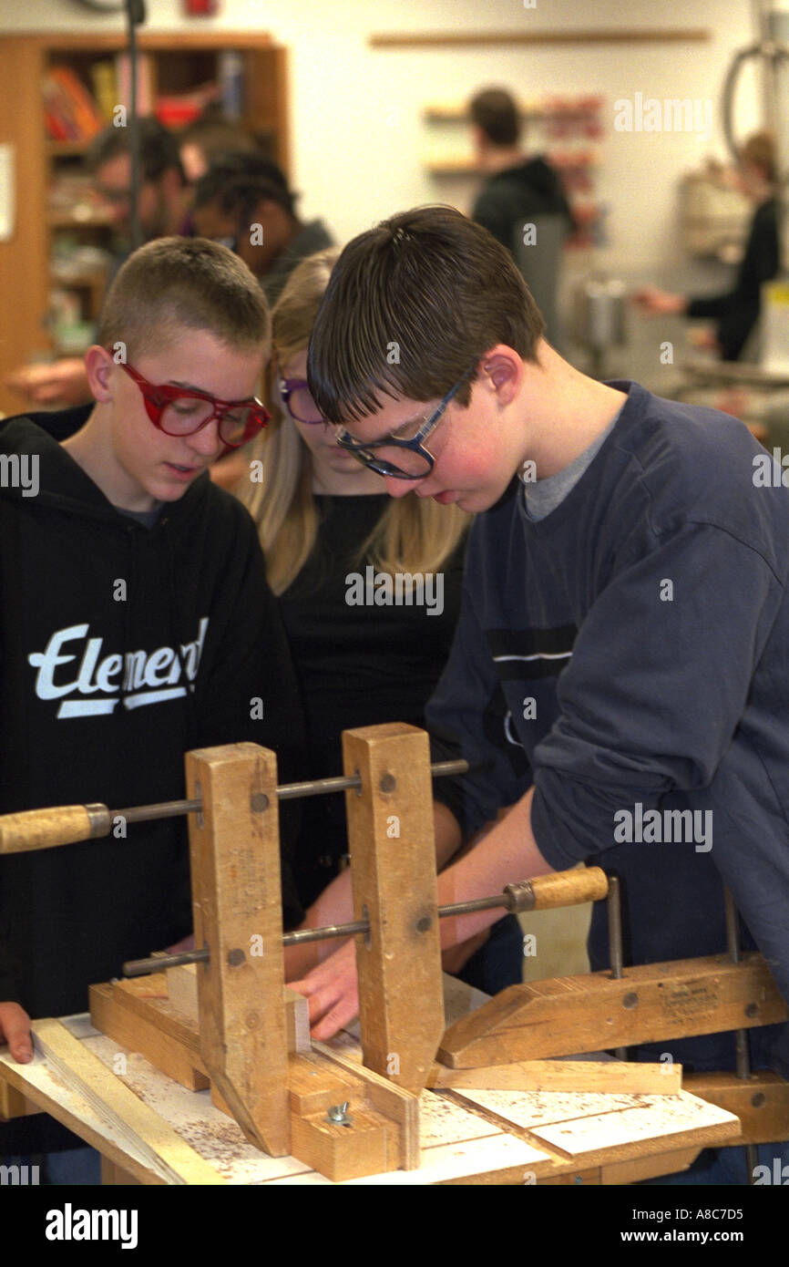 Students age 14 using wood clamp to fasten project to router in school ...