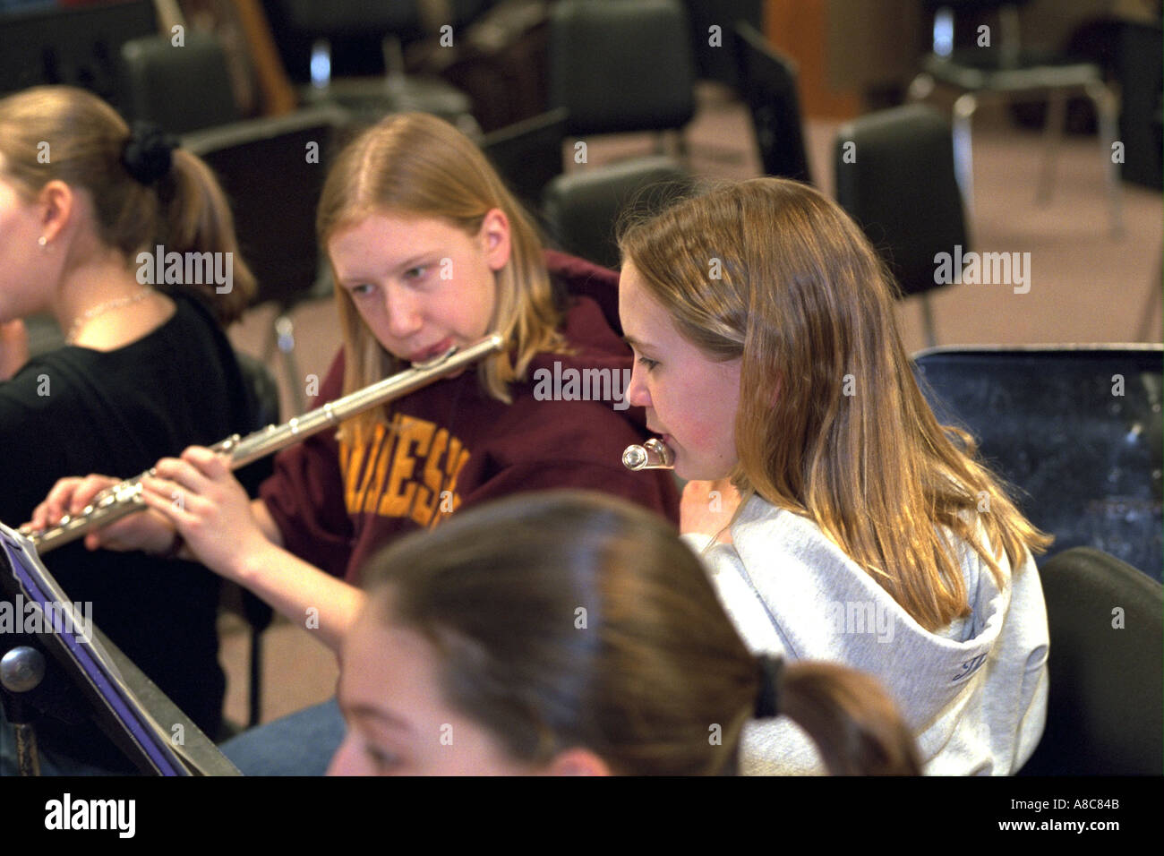 Flute players practicing at school orchestra rehearsal age 14. Golden ...