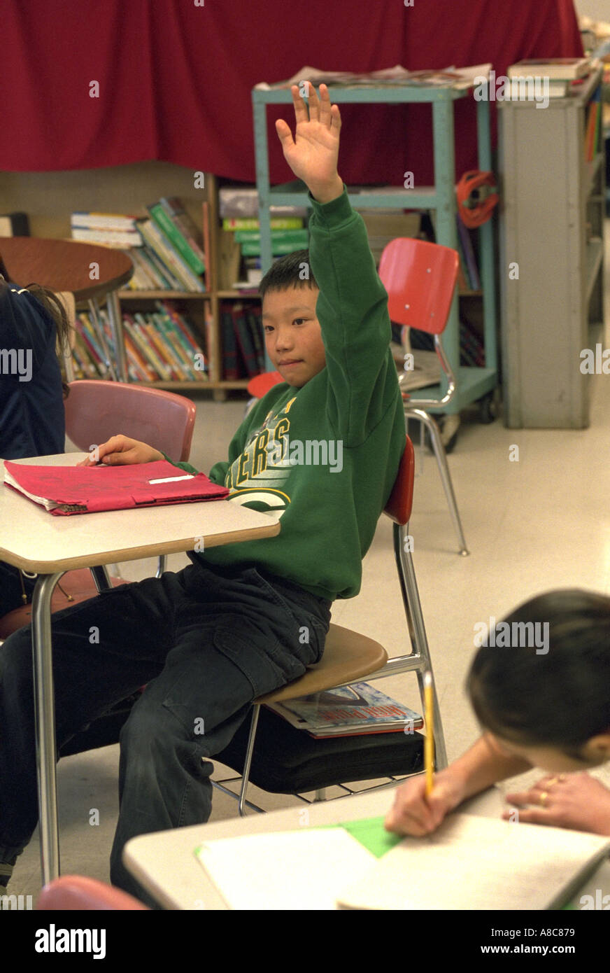 Student age 12 raising his hand in school ESL class. Golden Valley ...