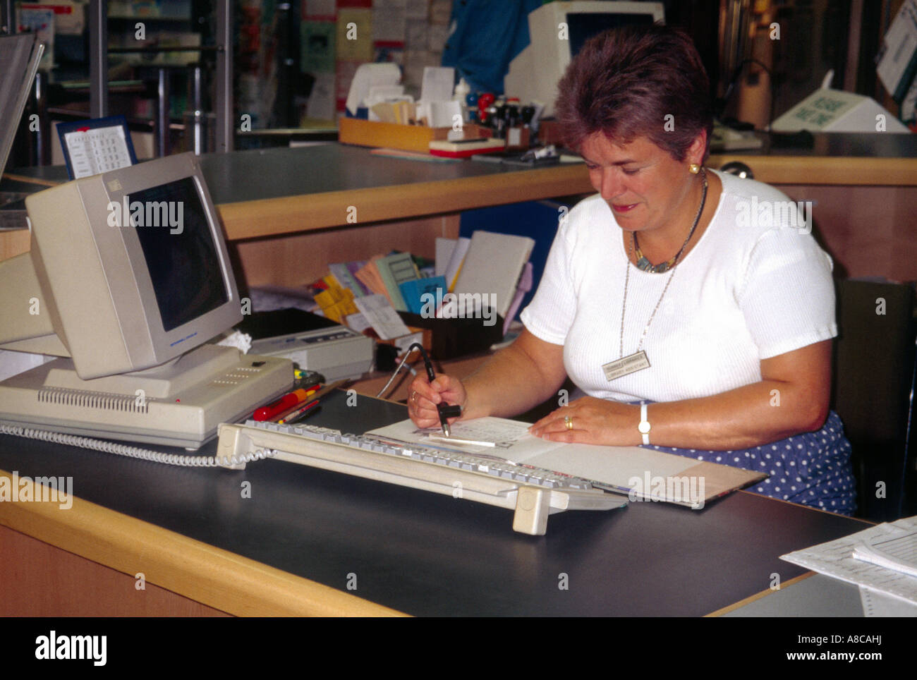 Librarian Working On Computer In Library Scanning Books Stock Photo - Alamy