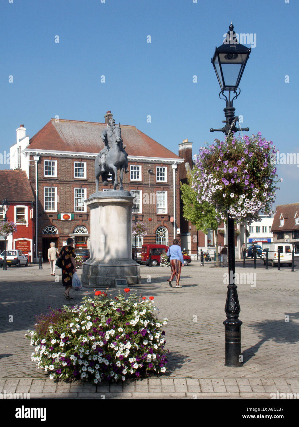 Summer flowers on a blue sky day in town centre market square with ...