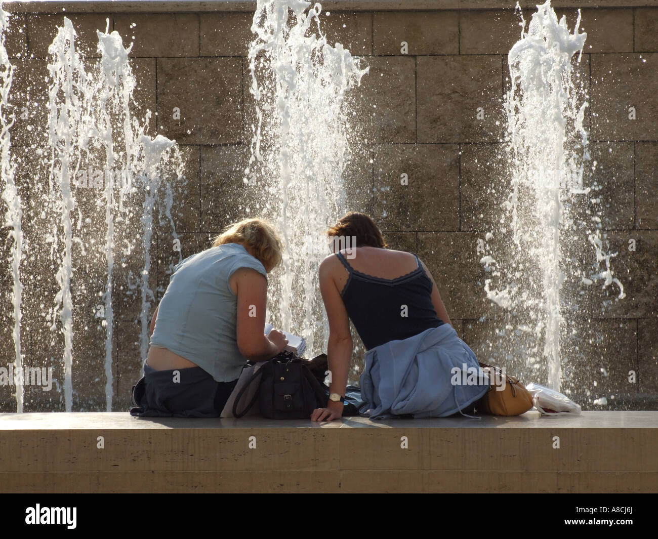 people sitting by water fountain in rome italy Stock Photo - Alamy