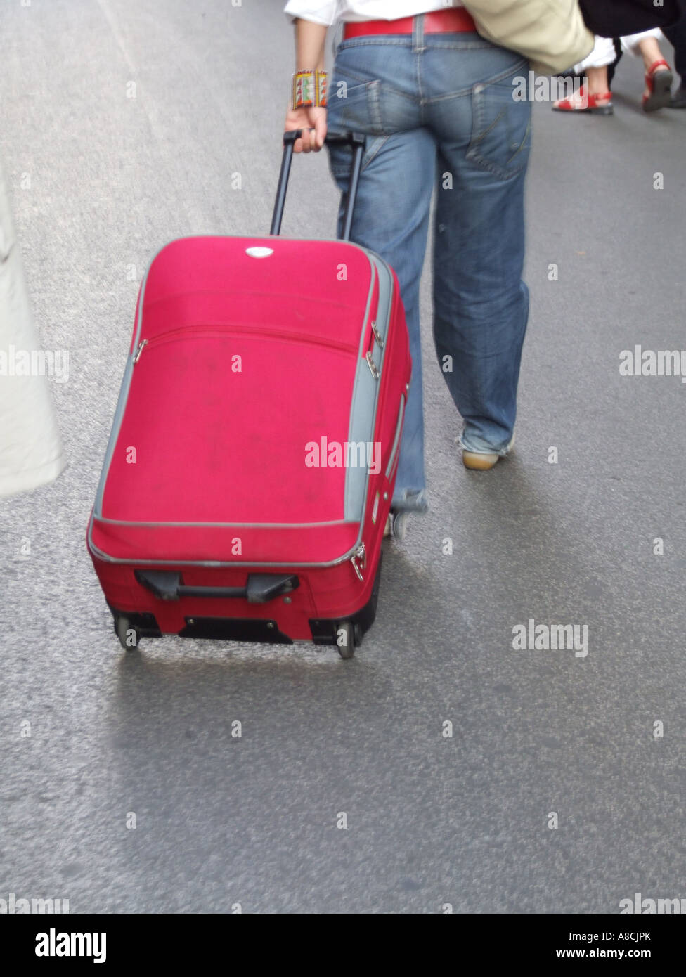 woman pulling trolley case in town Stock Photo - Alamy