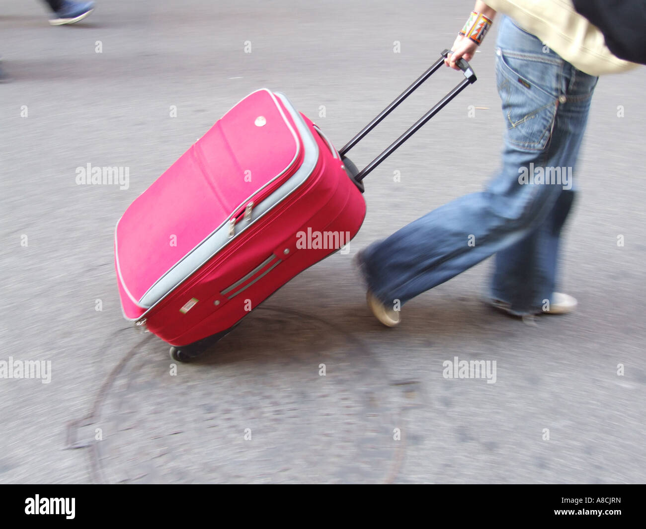 woman pulling trolley case in town Stock Photo - Alamy