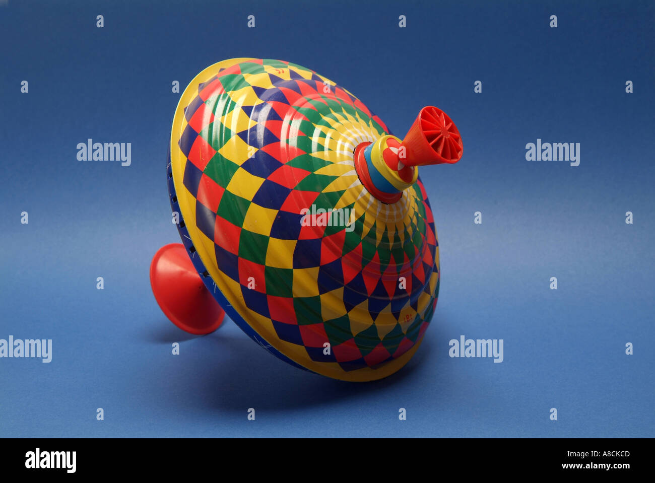 childrens spinning top toy on blue background Stock Photo - Alamy