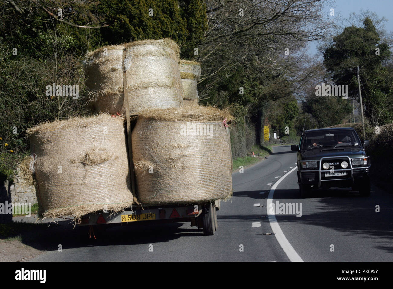 stuck behind tractor carrying large load of hay bails Stock Photo - Alamy