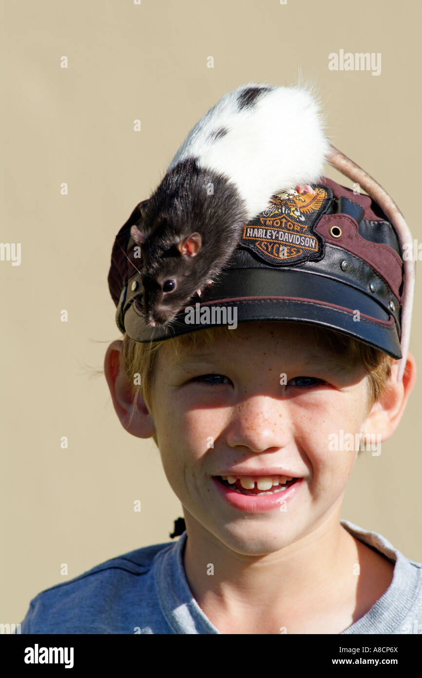 Boy with pet rat Young smiling boy with his pet rat sitting on his ...