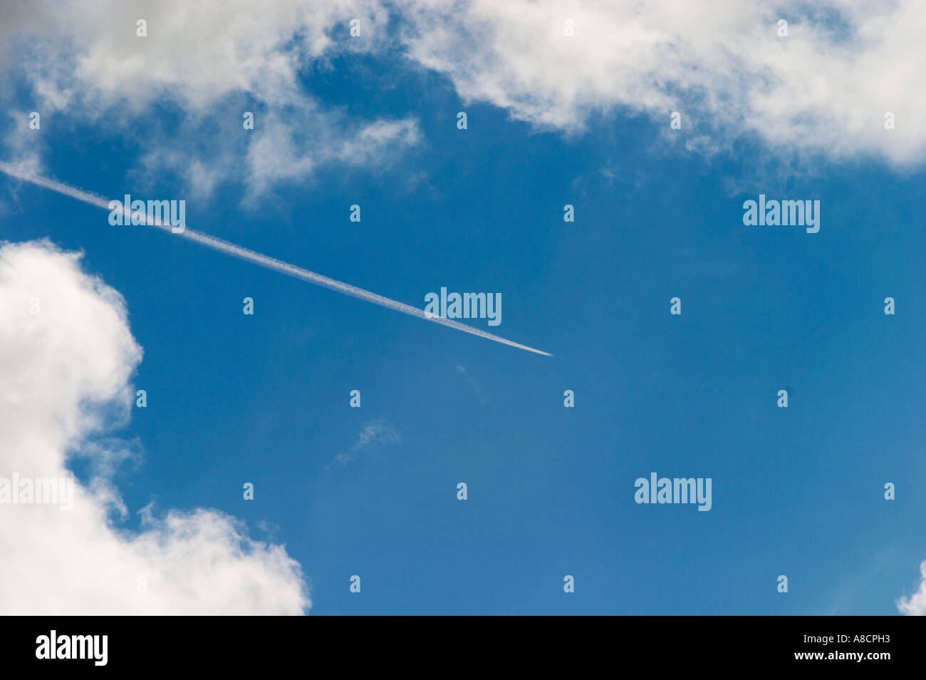 Jet airplane making vapor trail or contrail in sky with big white ...