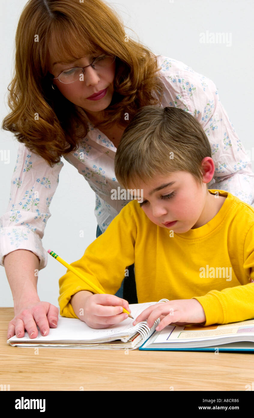 Mother or teacher helping boy with homework Stock Photo - Alamy