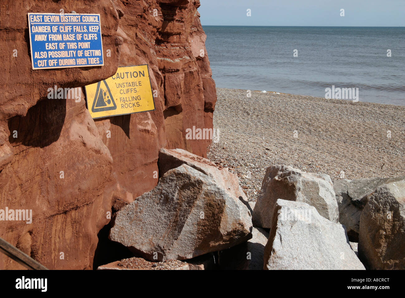 red cliffs and signs warning of unstable cliffs Sidmouth Devon UK Stock ...