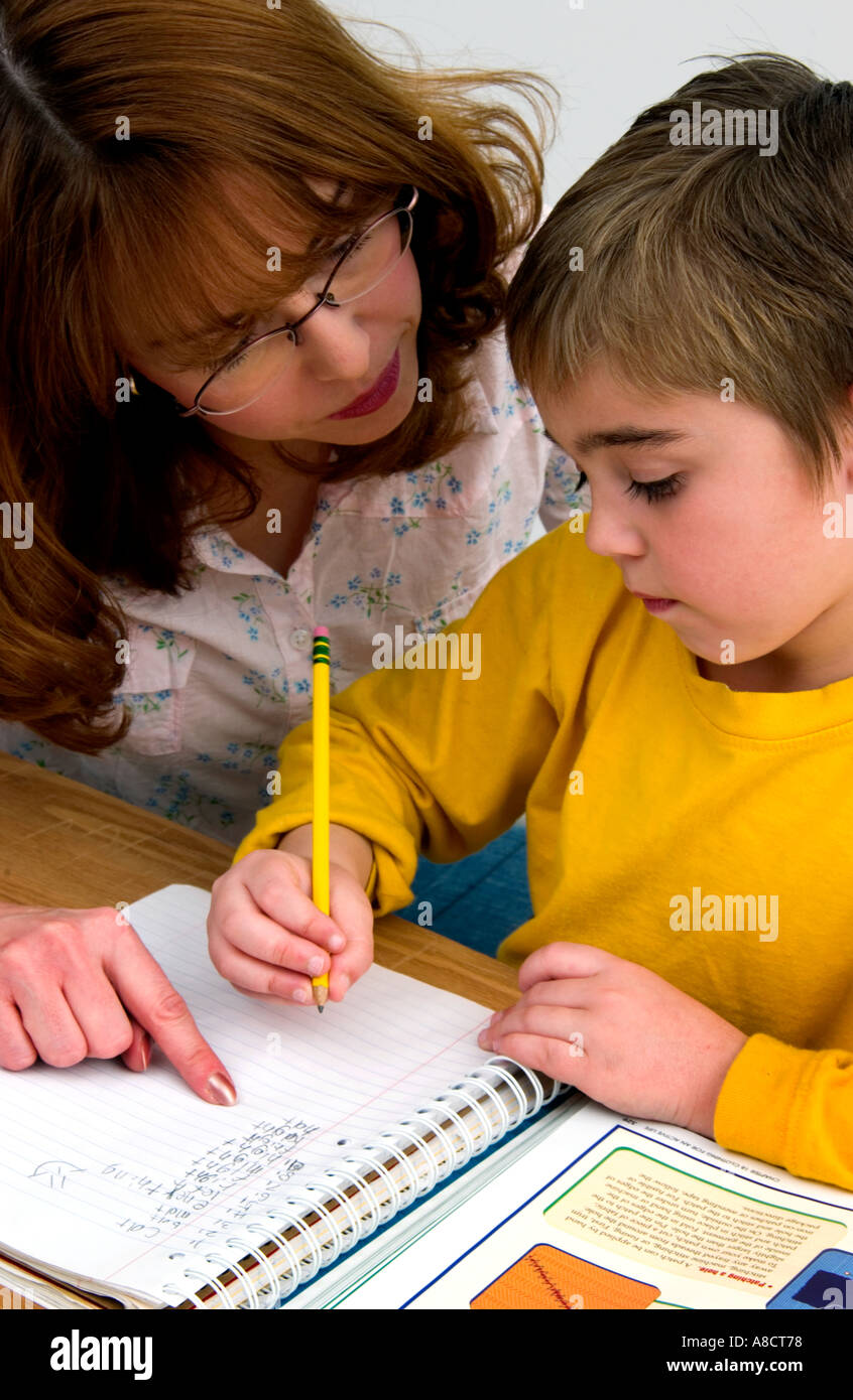 Mother or teacher helping boy with homework Stock Photo - Alamy