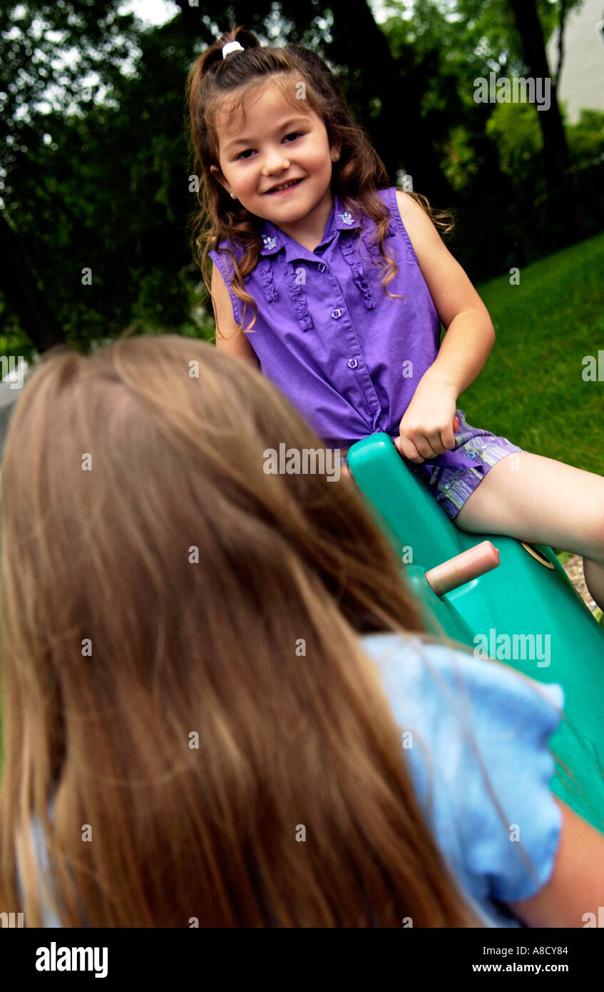 Girl on teeter totter Stock Photo - Alamy