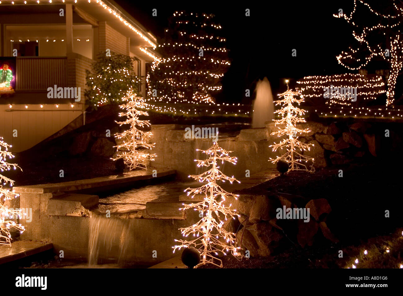 Trees Decorated With Christmas Lights Around A Fountain and Waterfalls ...
