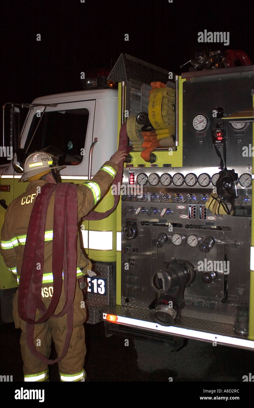 Fireman loading hose back on fire truck at a night fire drill Stock ...