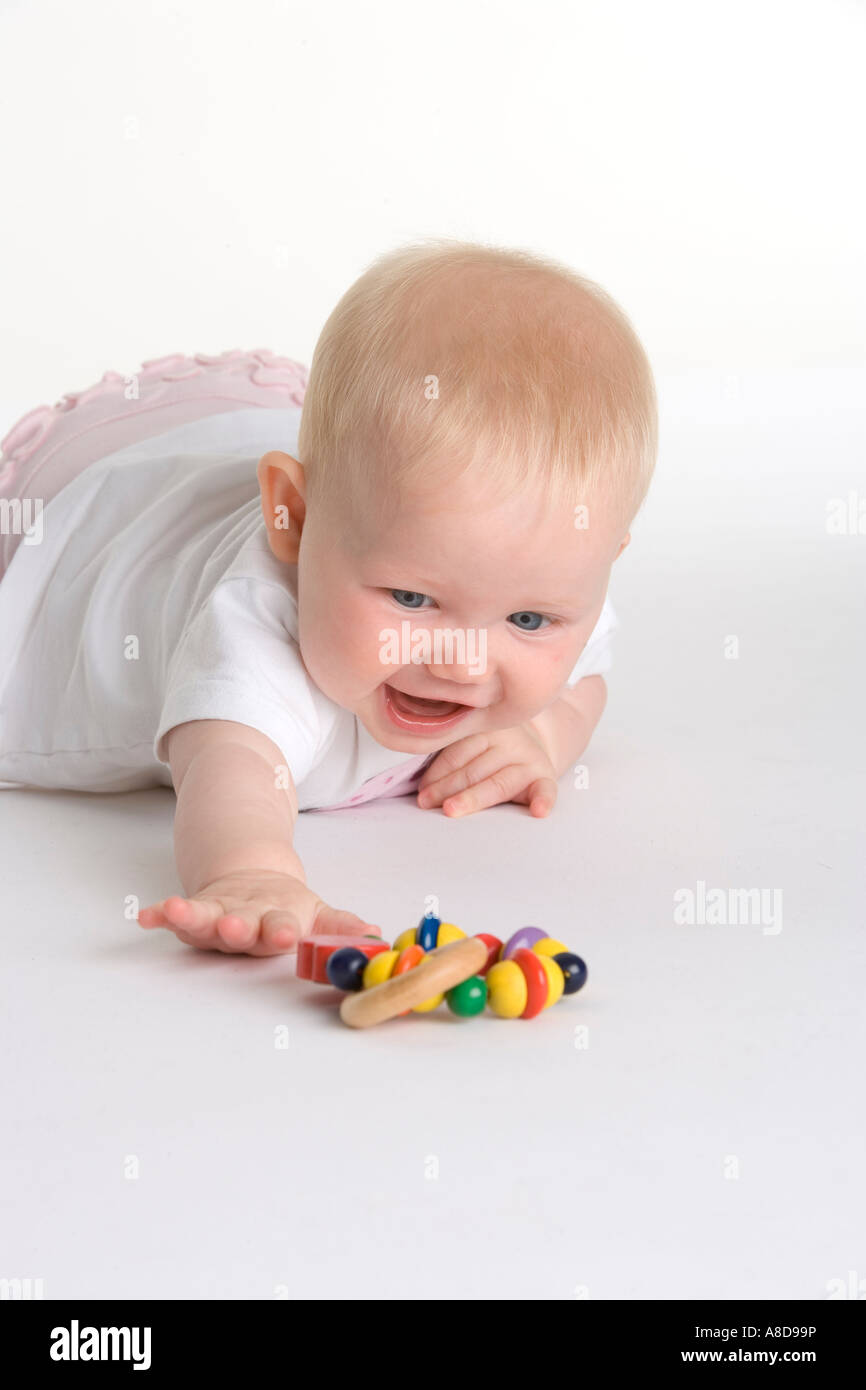 Baby reaching for a toy Stock Photo - Alamy