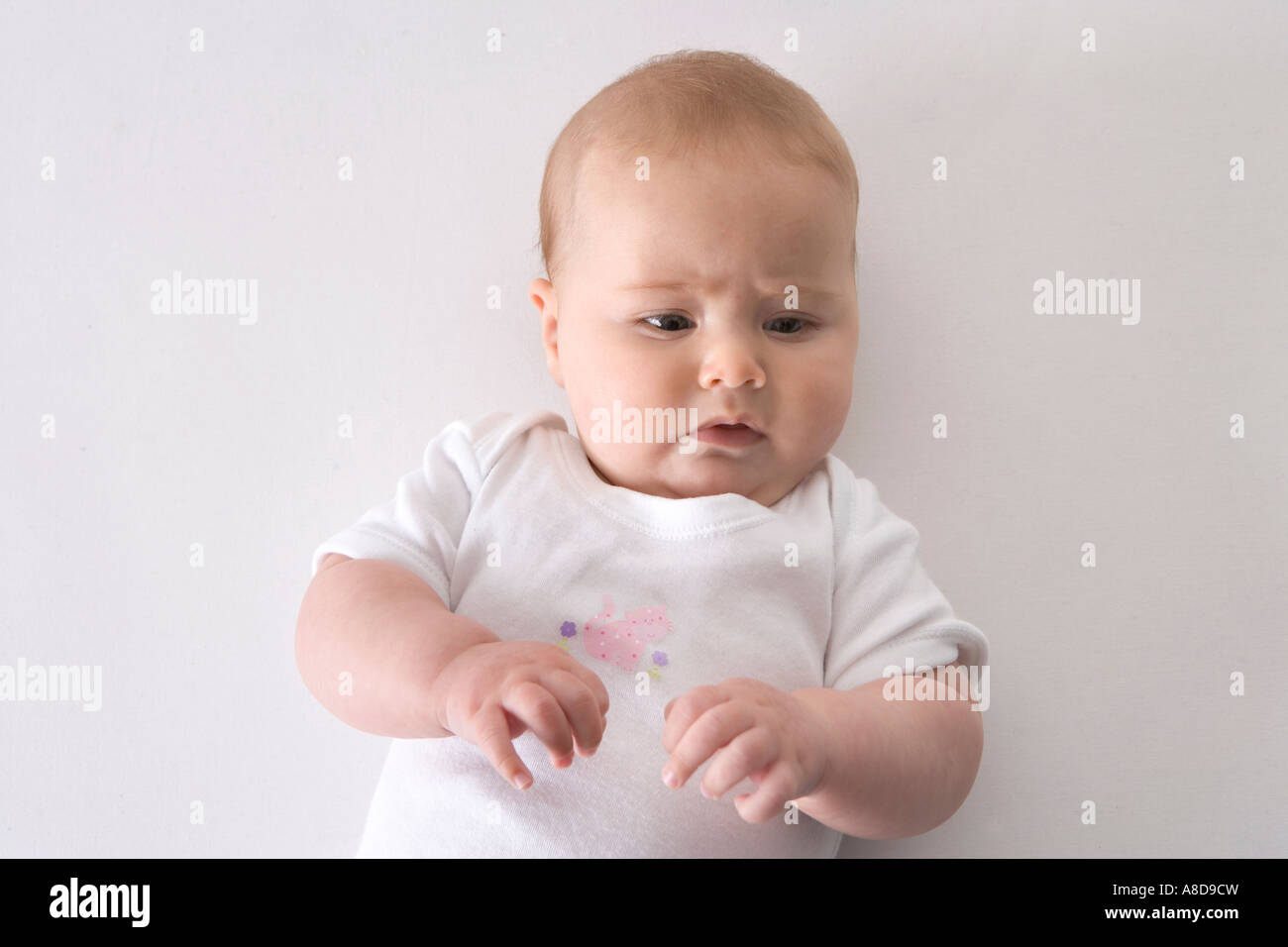 Annoyed baby girl lying on the floor Stock Photo - Alamy