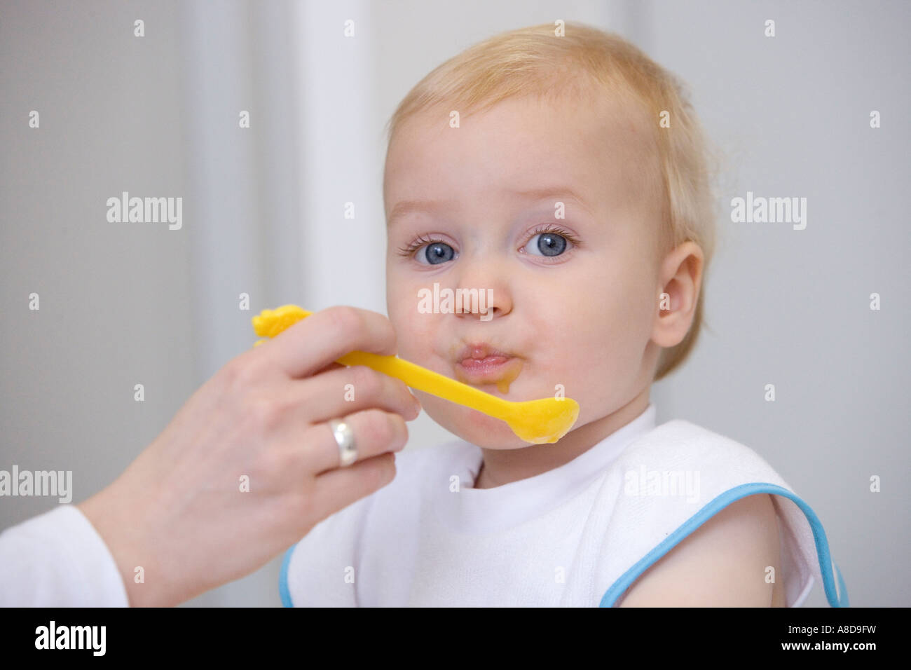 Little boy eating from a spoon Stock Photo - Alamy
