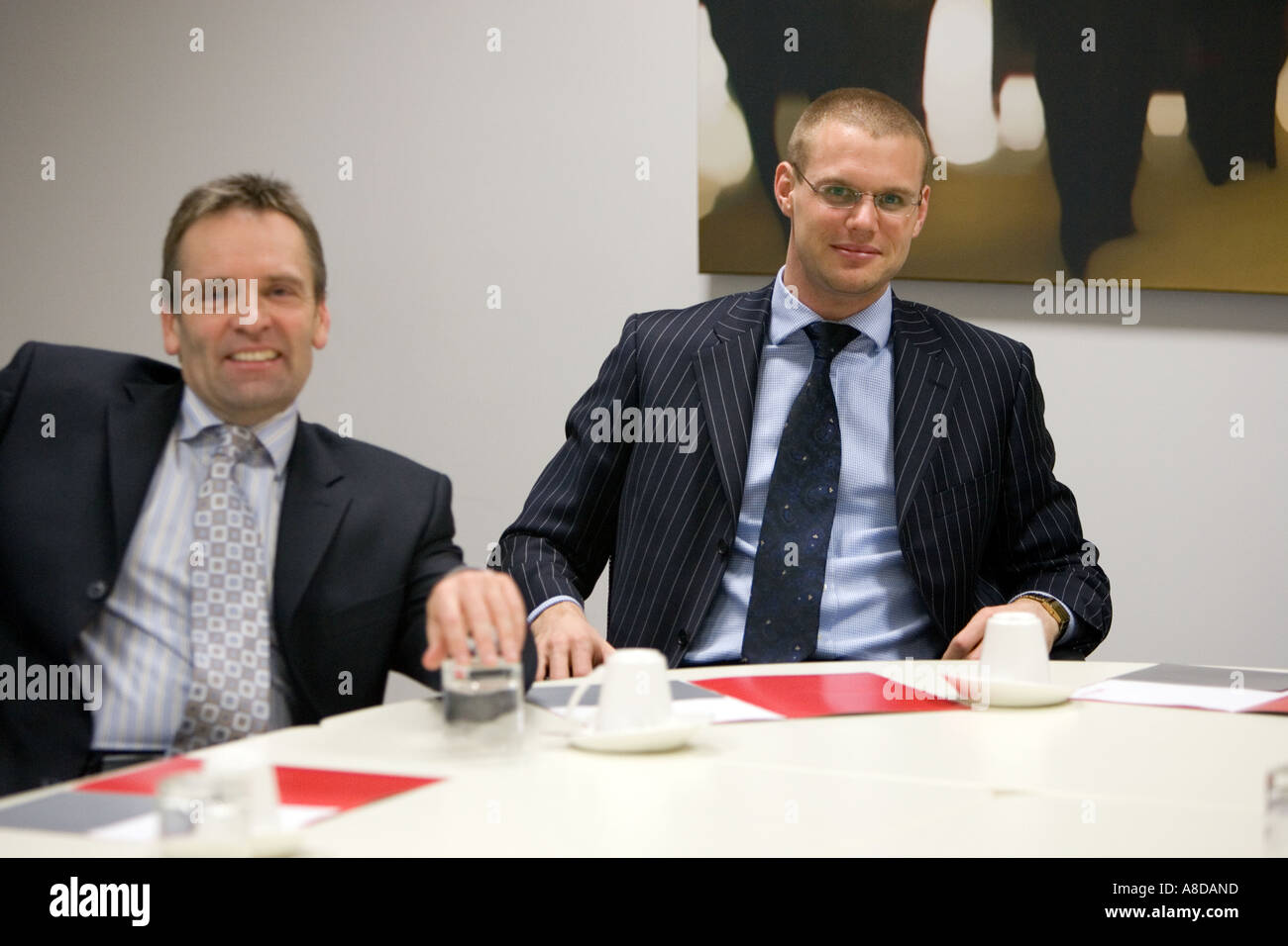 Businessmen posing for a commercial photoshoot in office boardroom ...