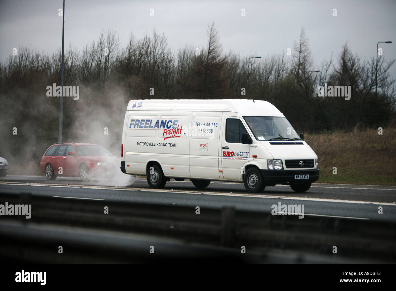 White Van making lots of smoke on motorway Stock Photo - Alamy