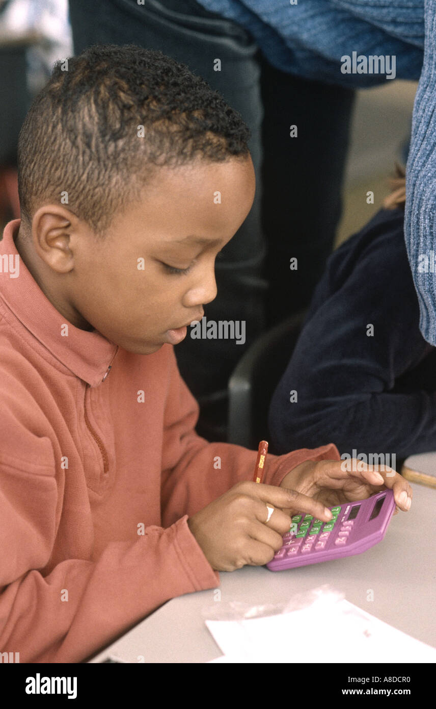 Primary school boy using a calculator Stock Photo - Alamy