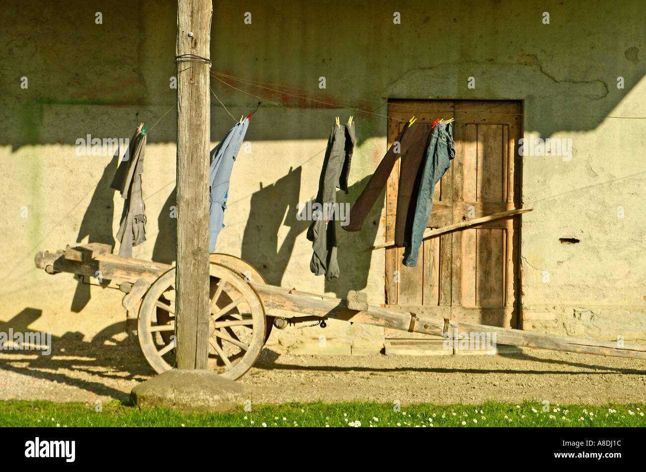 A line of washing dries under the verandah of an old barn with a wooden ...