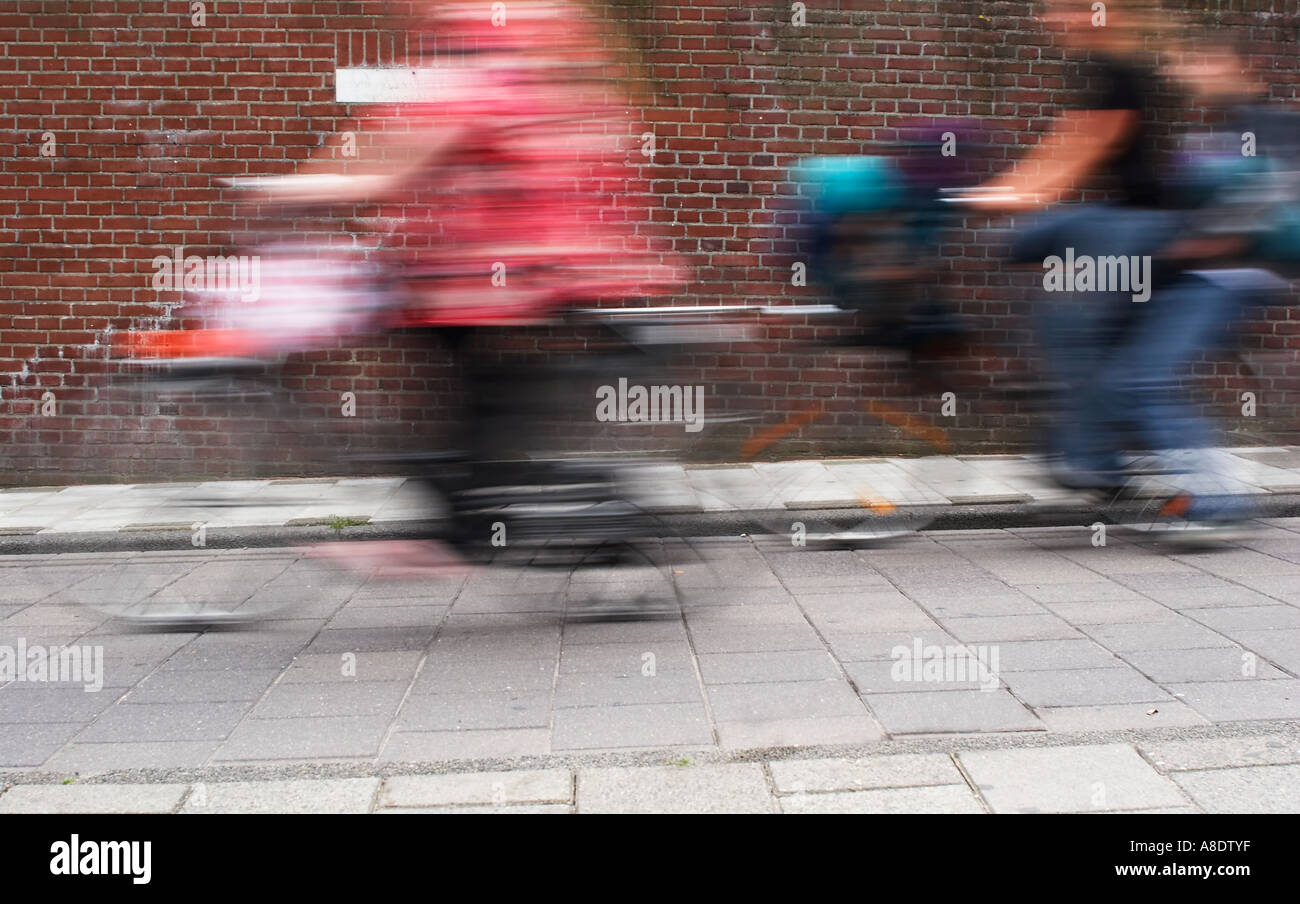 Cyclists Passing In Street Stock Photo - Alamy