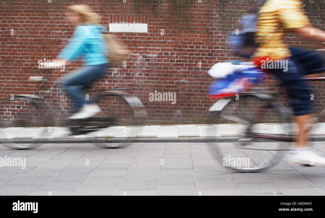 Cyclists Passing In Street Stock Photo - Alamy