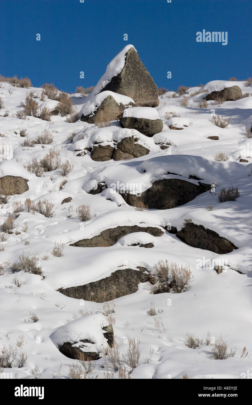 Prevailing wind has blown snow to one side of this rock formation Stock ...